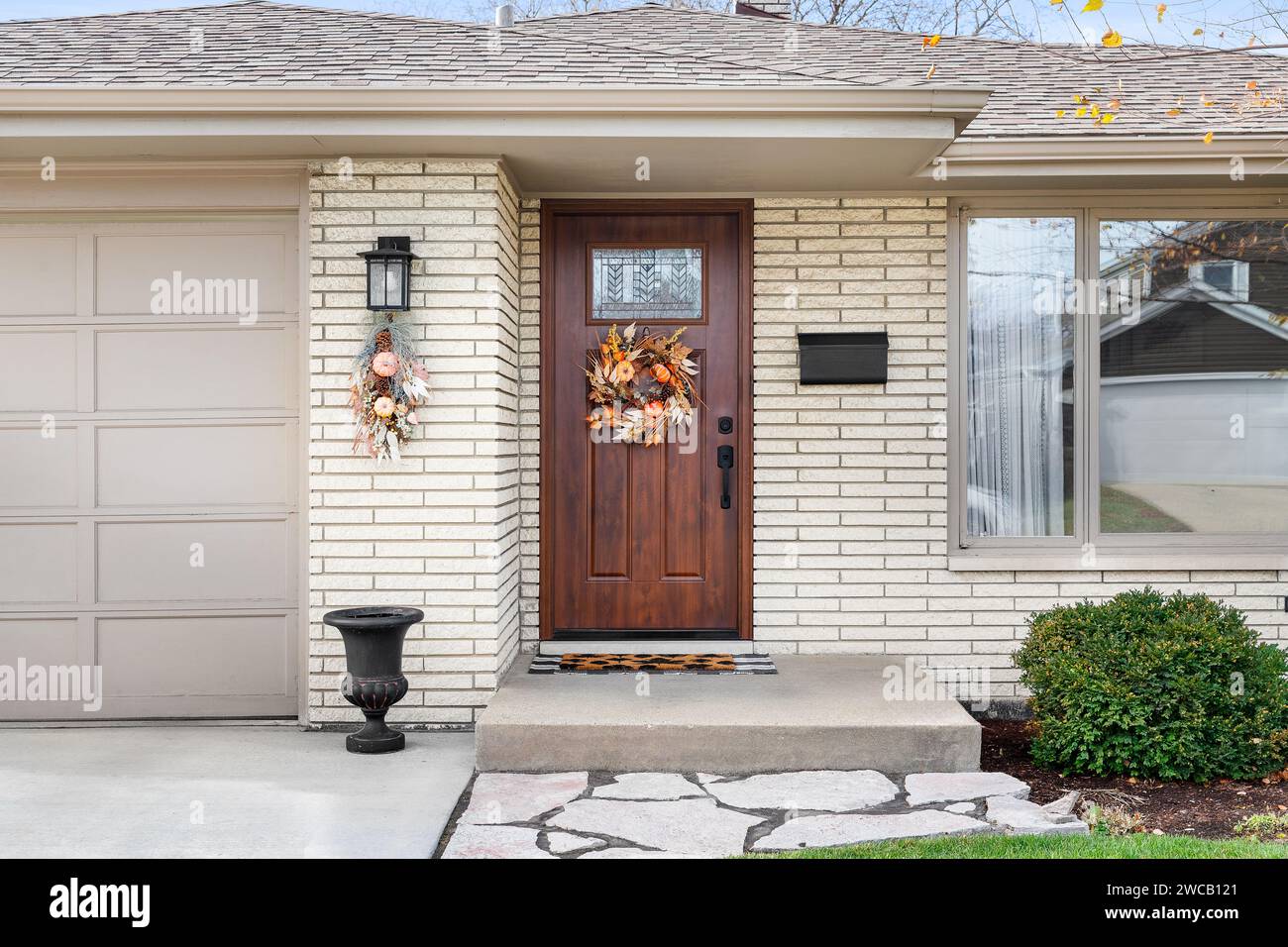 A ranch, home front door detail with a wooden front door and off white ...