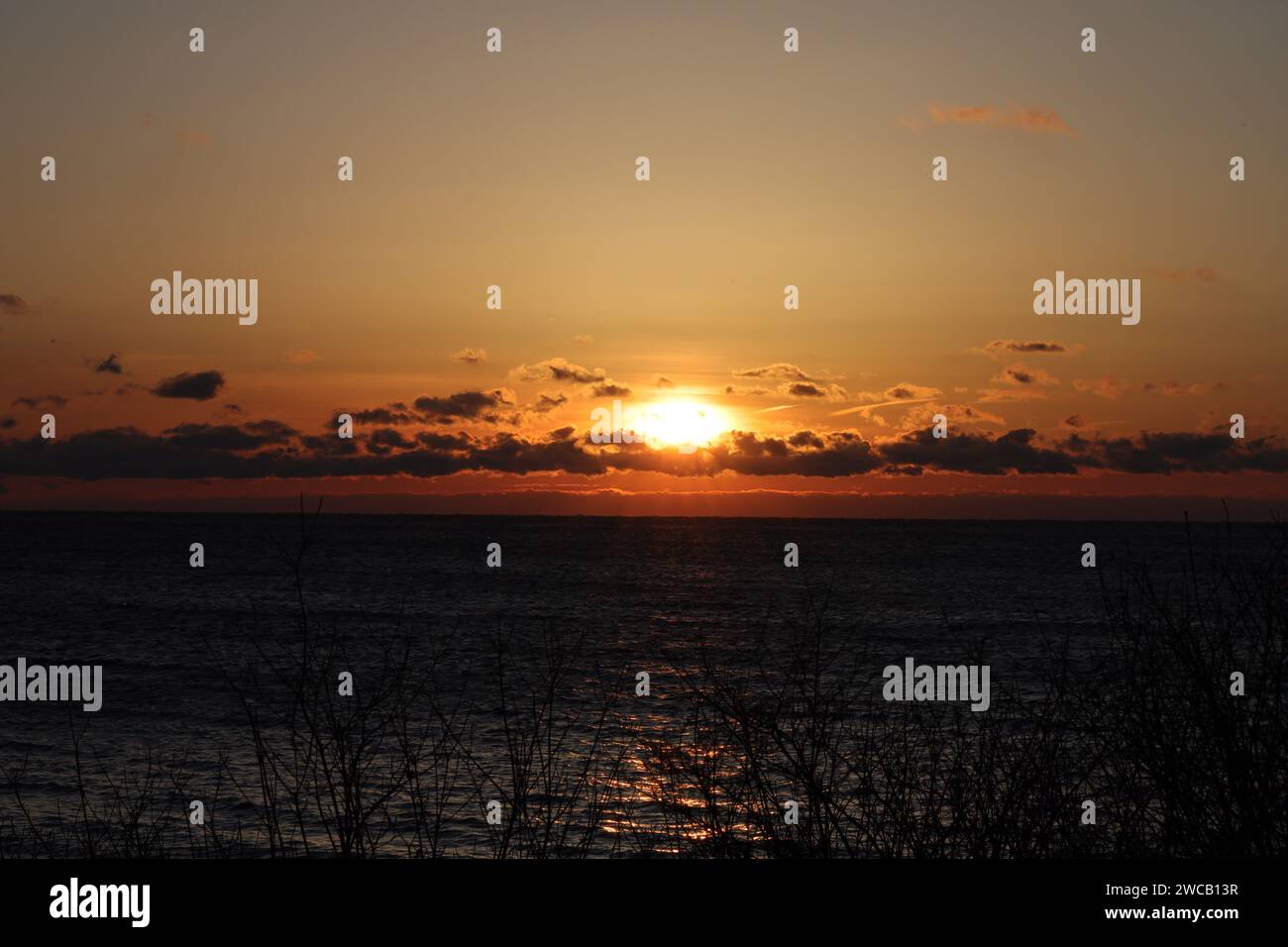 An image of the water, clouds, and dark sky in the early dawn, just as ...