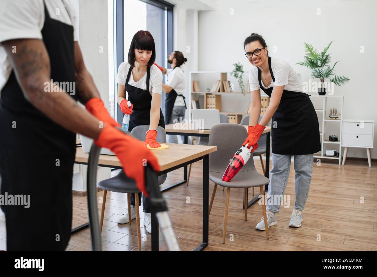 Happy smiling multicultural employees of company cleaning in bright ...
