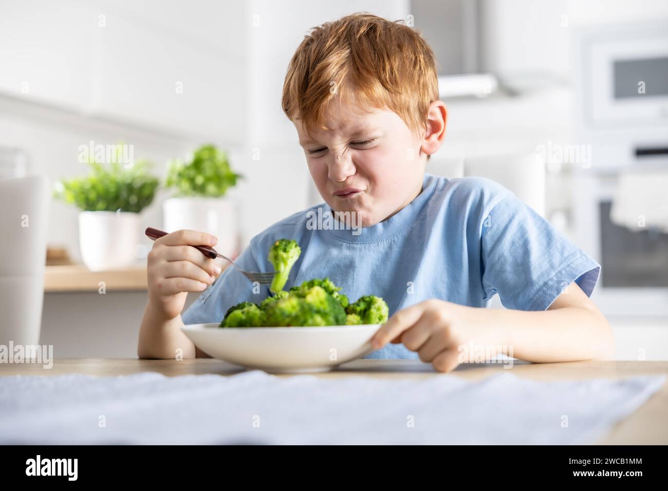 The little boy looks with distaste at the broccoli on his fork Stock ...