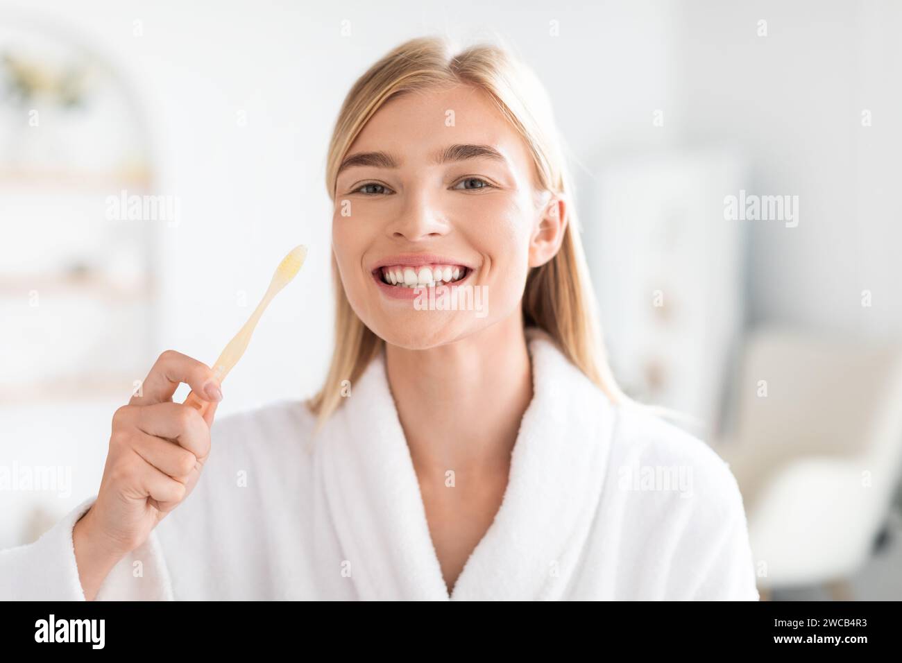 European blonde woman maintaining oral health brushing teeth in ...
