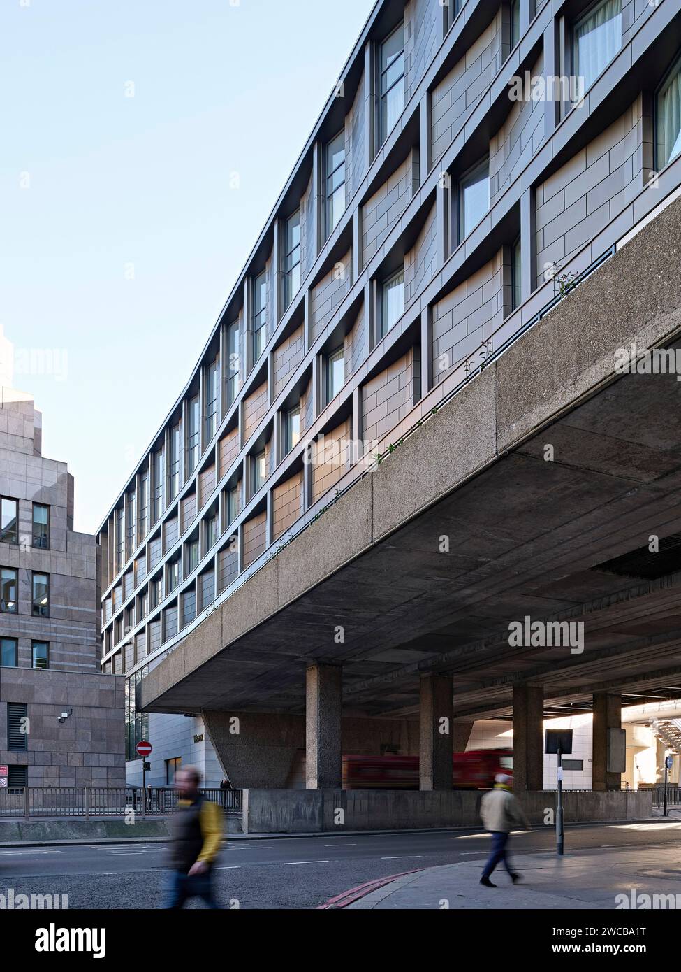 Elevation of building volume bridging city street and cycle path. The ...