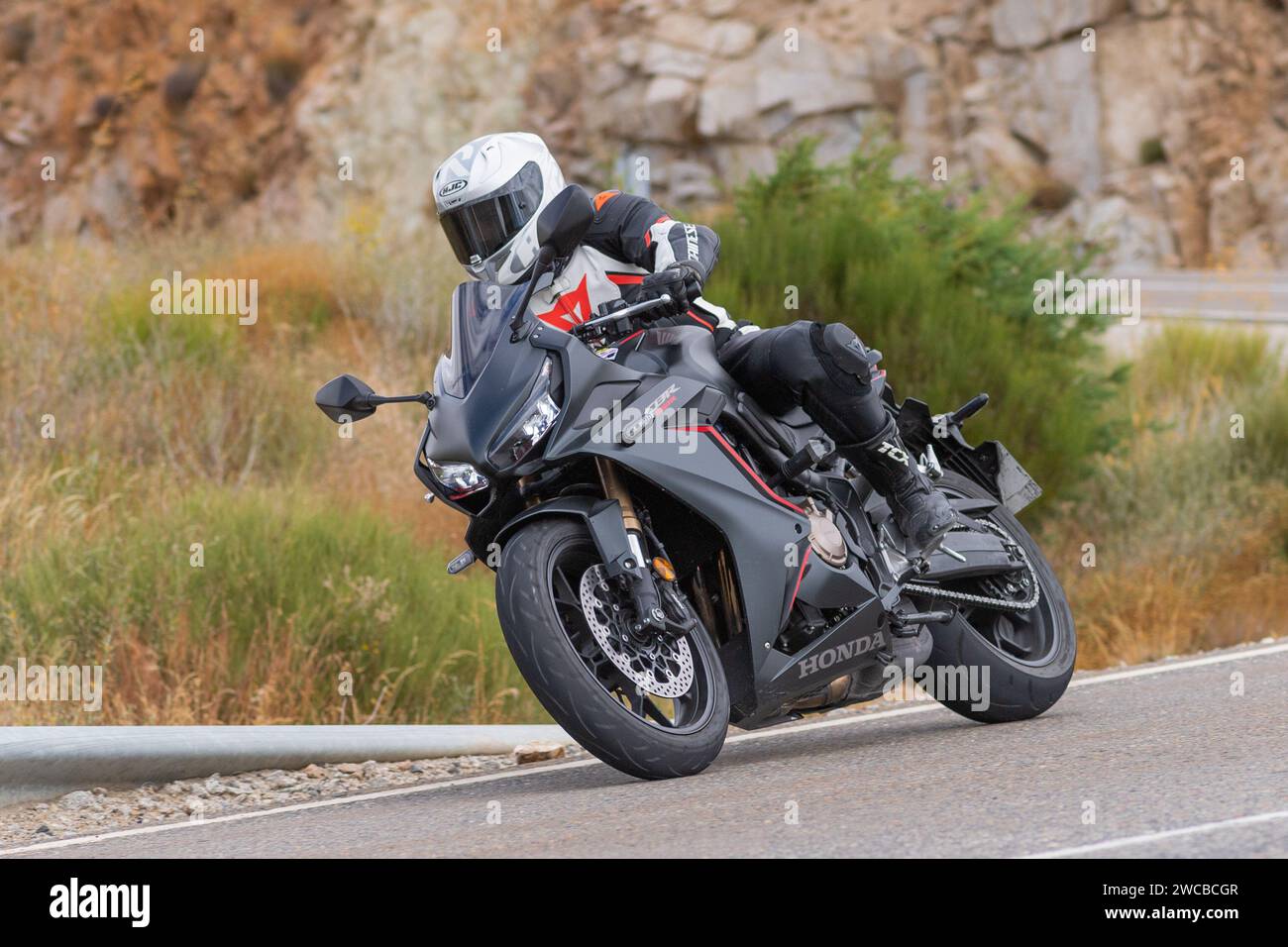 young man driving his motorcycle on a bend on the road, photography on ...