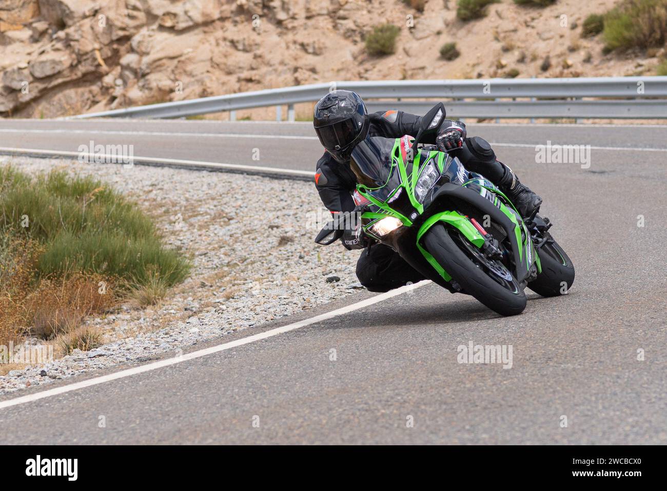 young man driving his motorcycle on a bend on the road, photography on ...