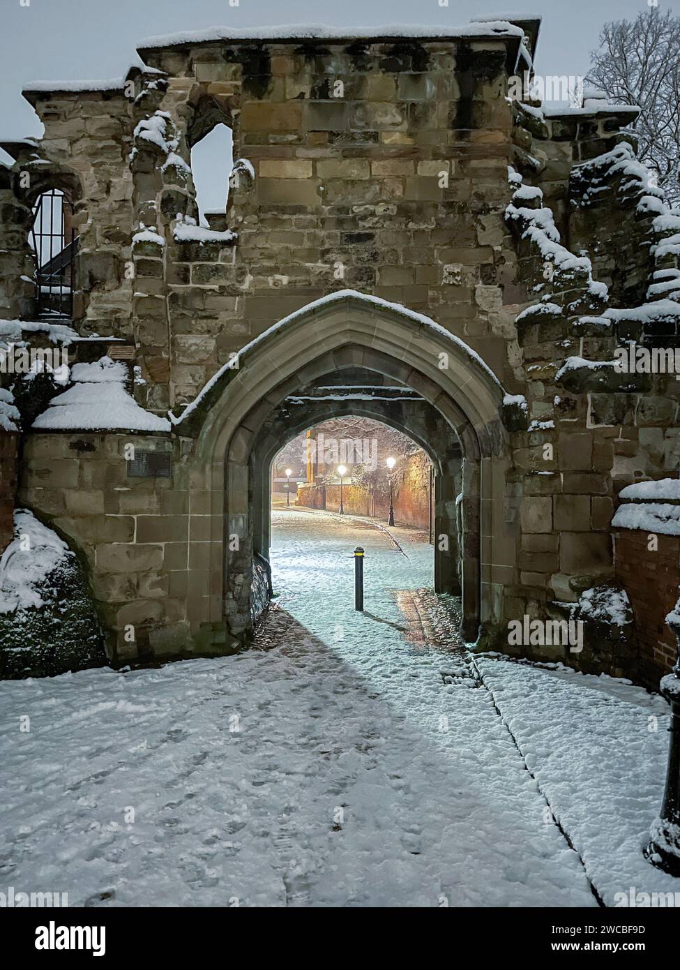 A snow covered Leicester's Castle Turret Gateway illuminated by street ...