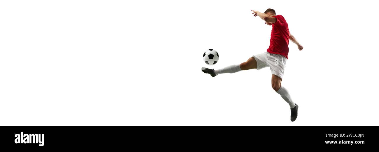 Precision in Flight. Football player kicks ball into air, creating ...