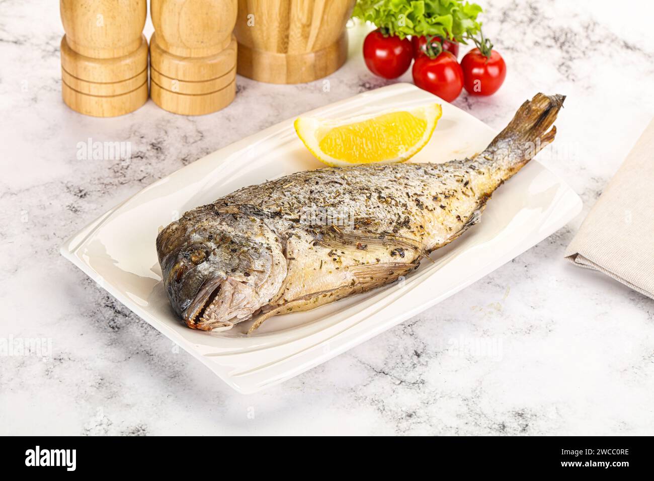 Baked Dorado fish served lemon slice Stock Photo - Alamy