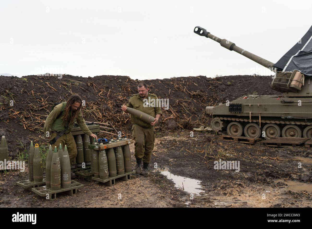 Israeli soldiers prepare to load a mobile howitzer in the north of ...