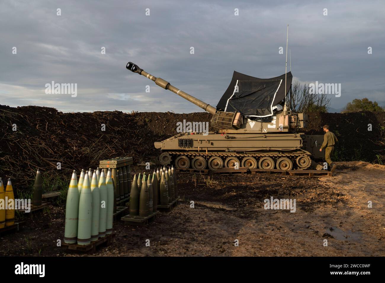 An Israeli soldier walks to a mobile howitzer in the north of Israel ...
