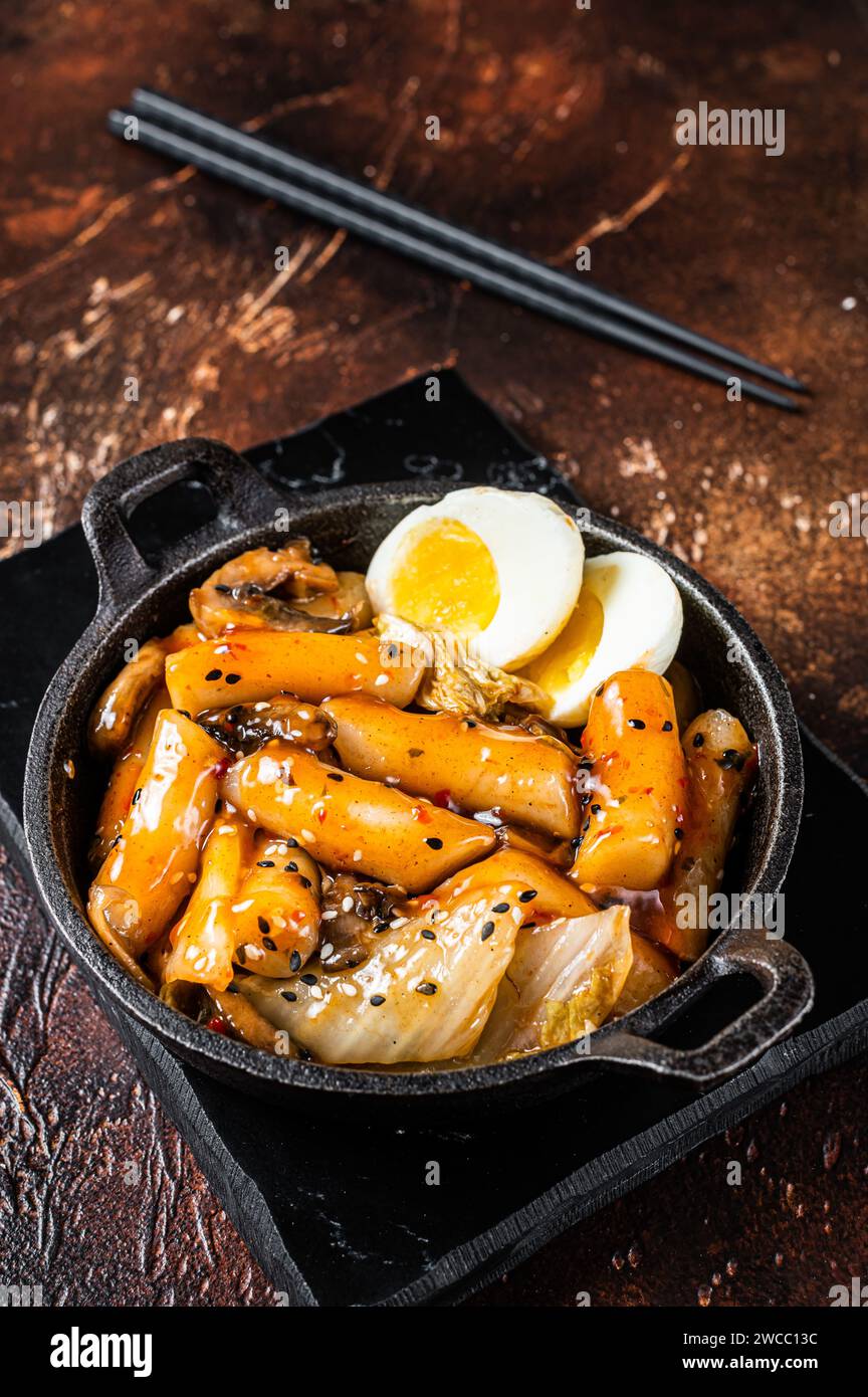 Korean Topokki or Tteokbokki rice cake with egg and mashrooms. Dark ...