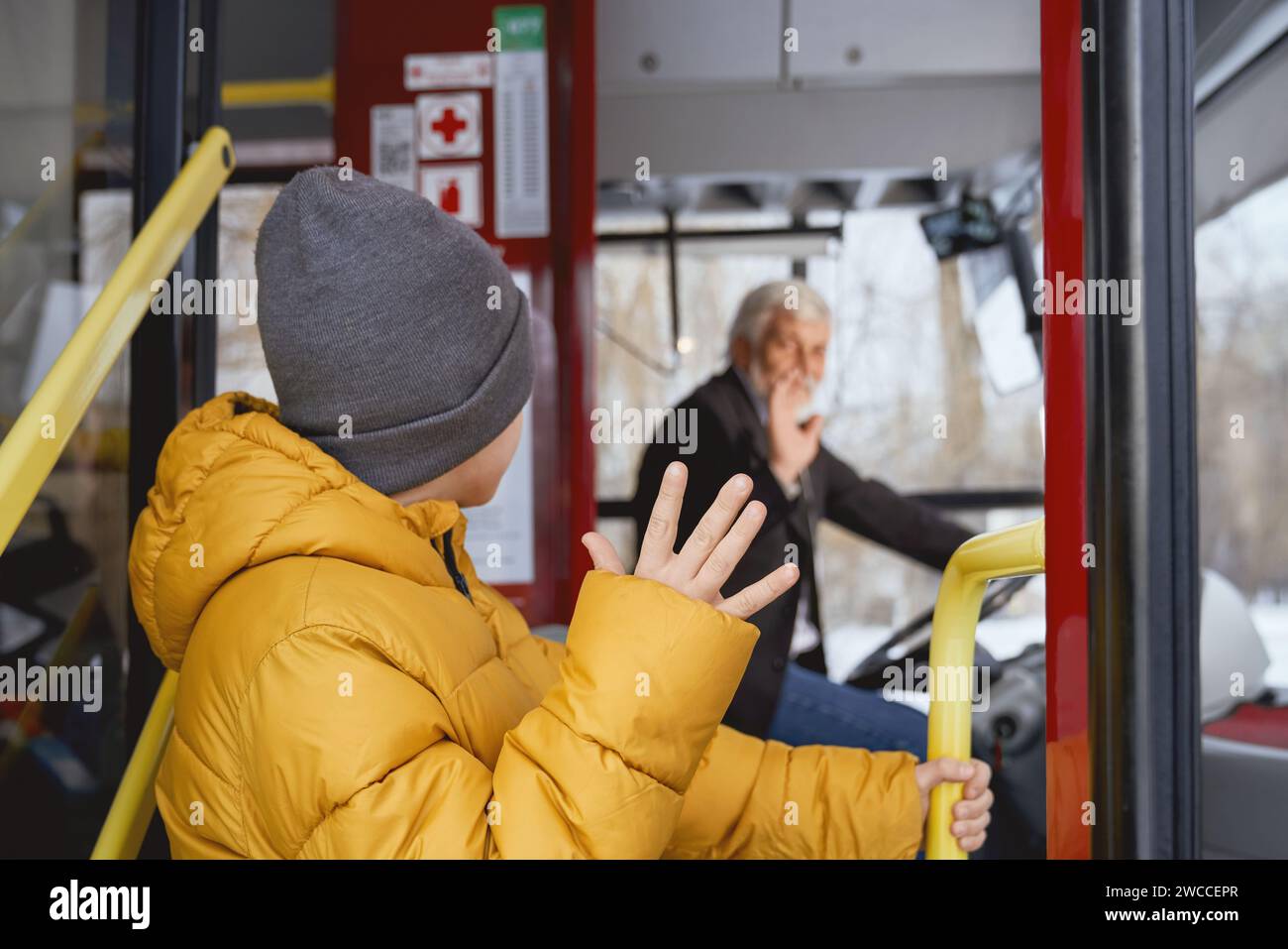 Back view of little boy in grey cap standing near open door saying ...
