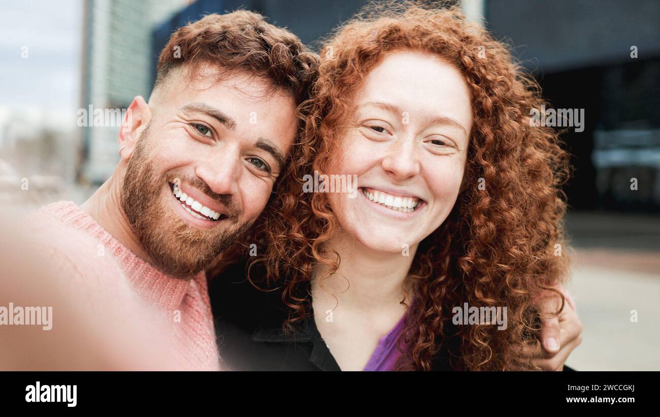 Happy ginger hair brother and sister having fun taking selfie picture ...
