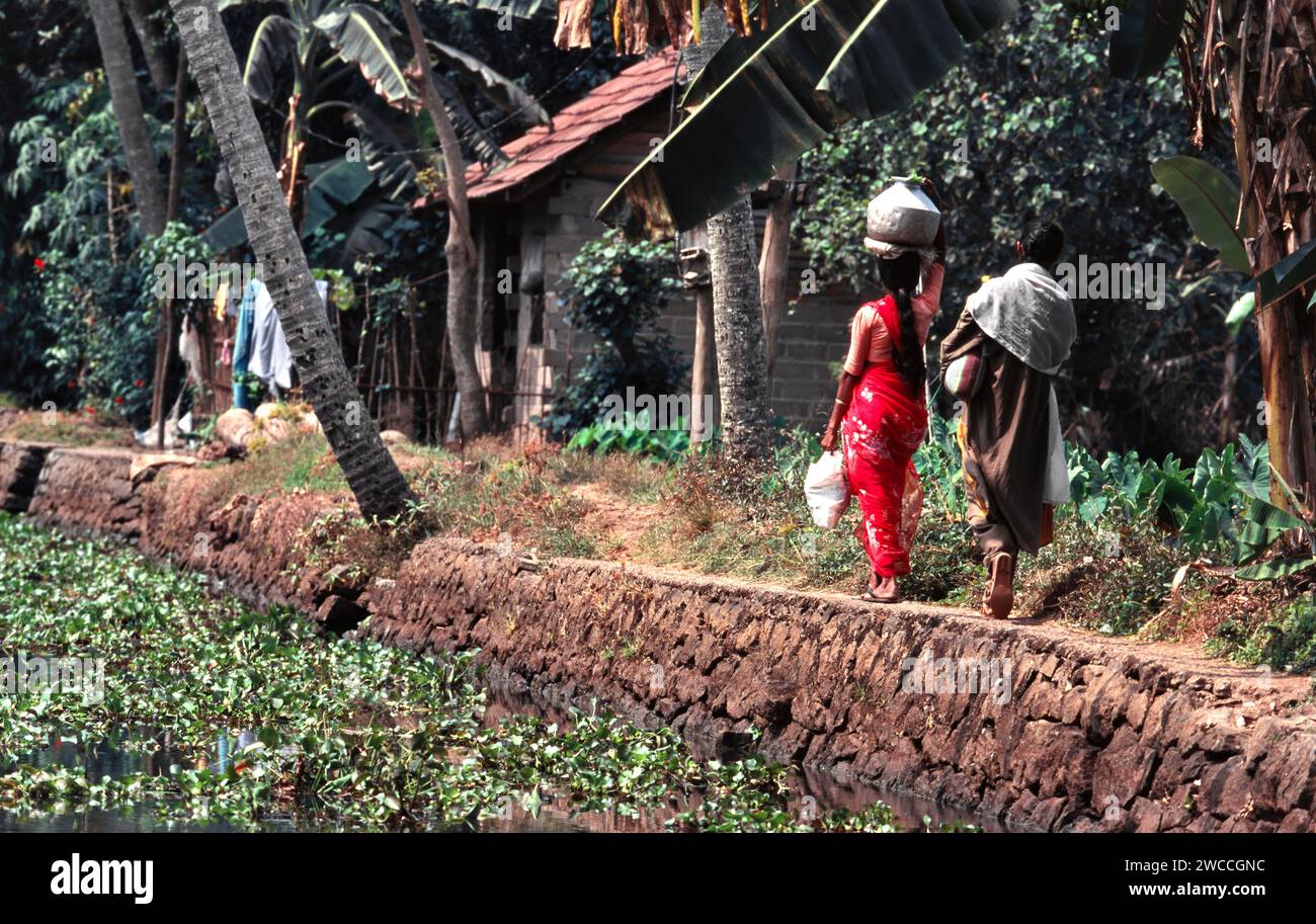 Rural India couple on a pathway alongside a backwater canal Kerala ...