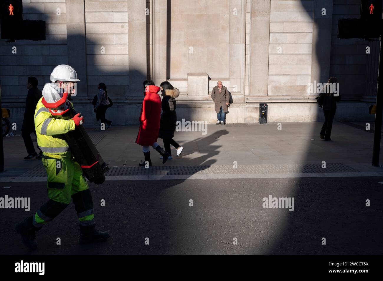 A workman with streets contractor Conway carries a heavy bollard ...