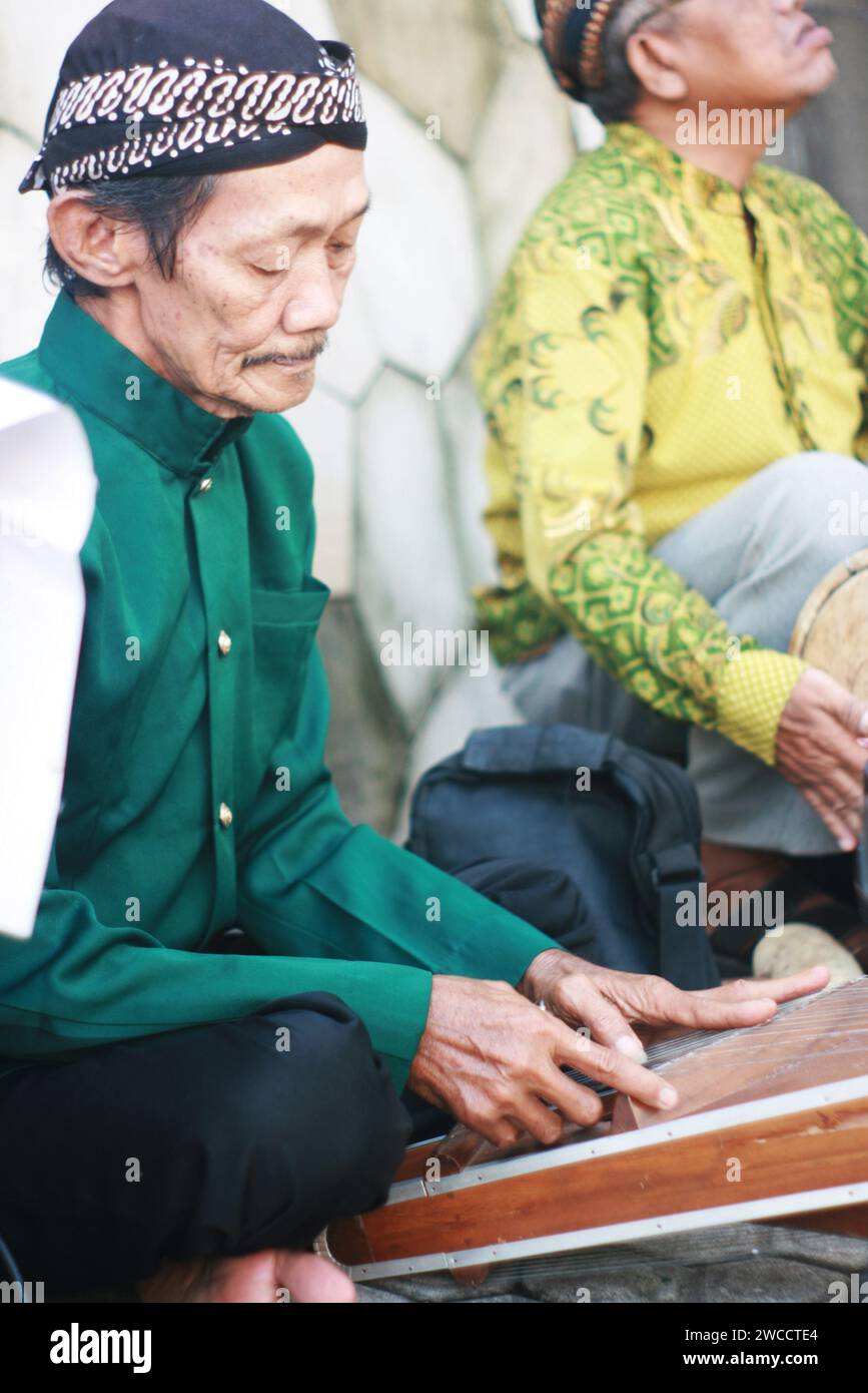 Senior adult traditional Indonesian musicians playing music called ...