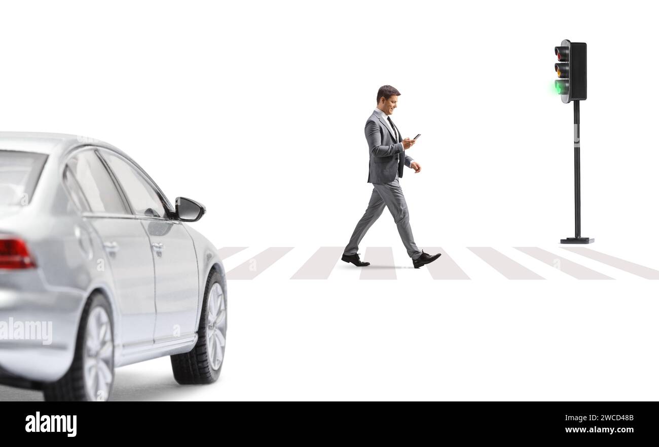 Man using a smartphone and walking in front of a car at a pedestrian ...