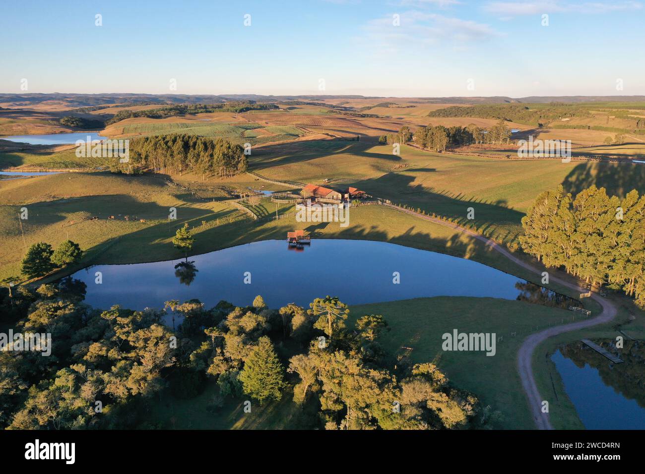 Farm with lake, trees and blue sky Stock Photo - Alamy