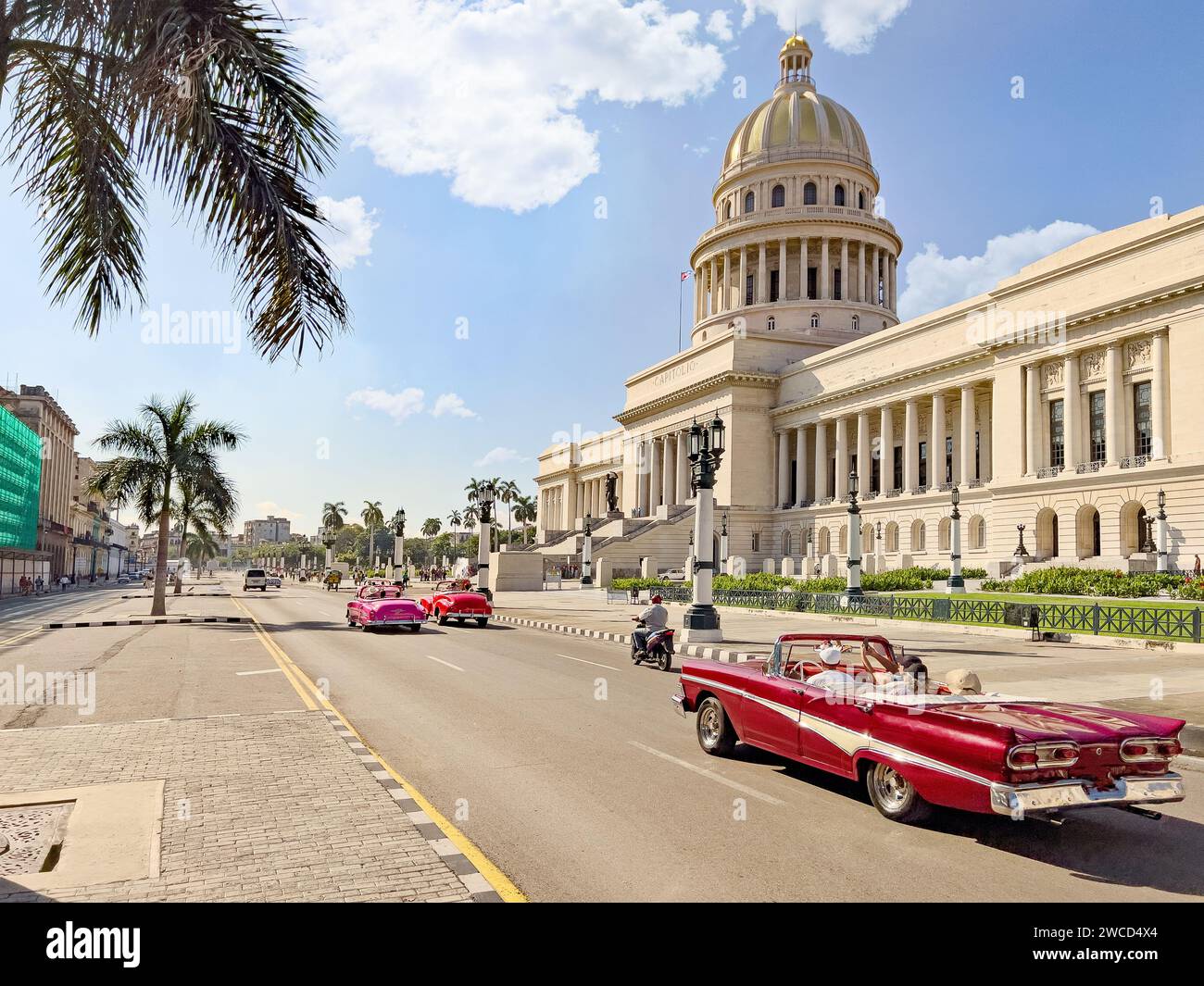 Convertible cars driving on the street in front of El Capitolio ...