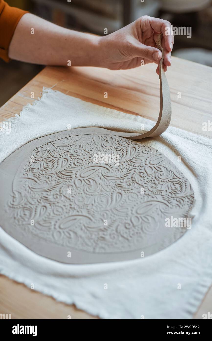 Hand modelling of openwork clay plate, pottery Stock Photo - Alamy