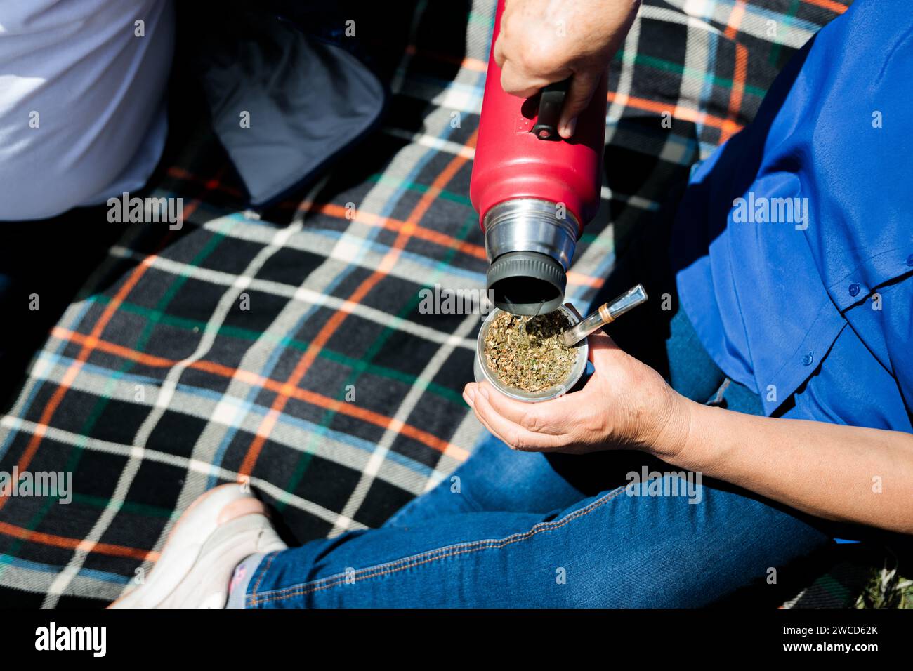 Top view of an unrecognizable latin senior couple serving and drinking ...