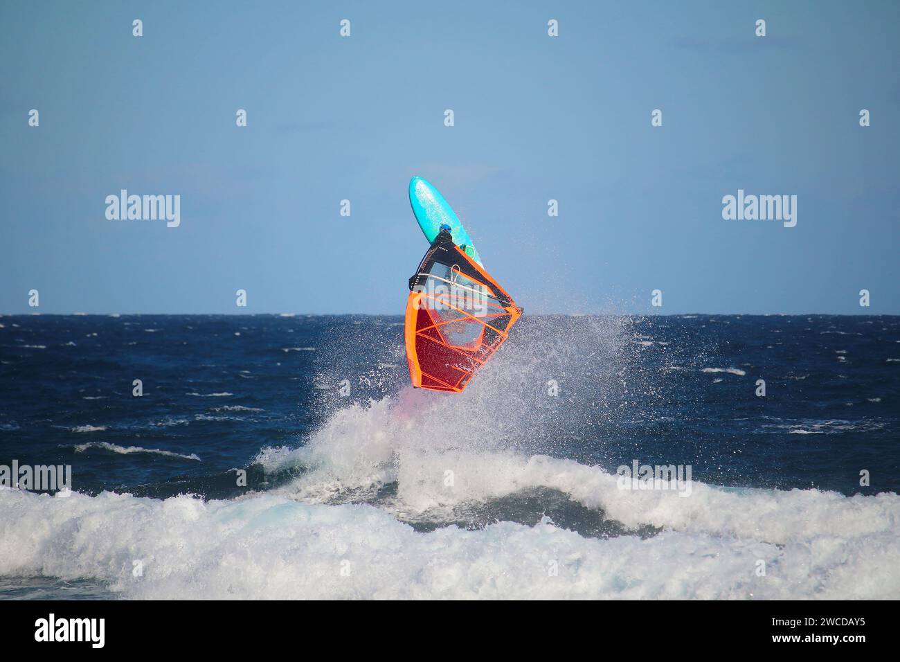 Windsurfer performing a back loop in the wave of the Atlantic ocean ...