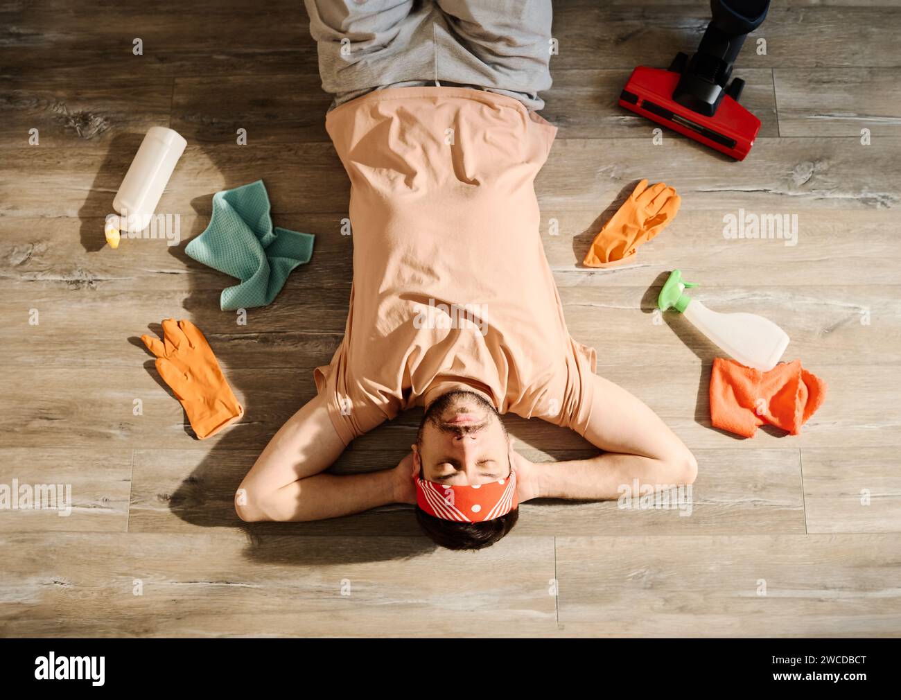 Top view of young tired man in casualwear and headband lying on clean ...