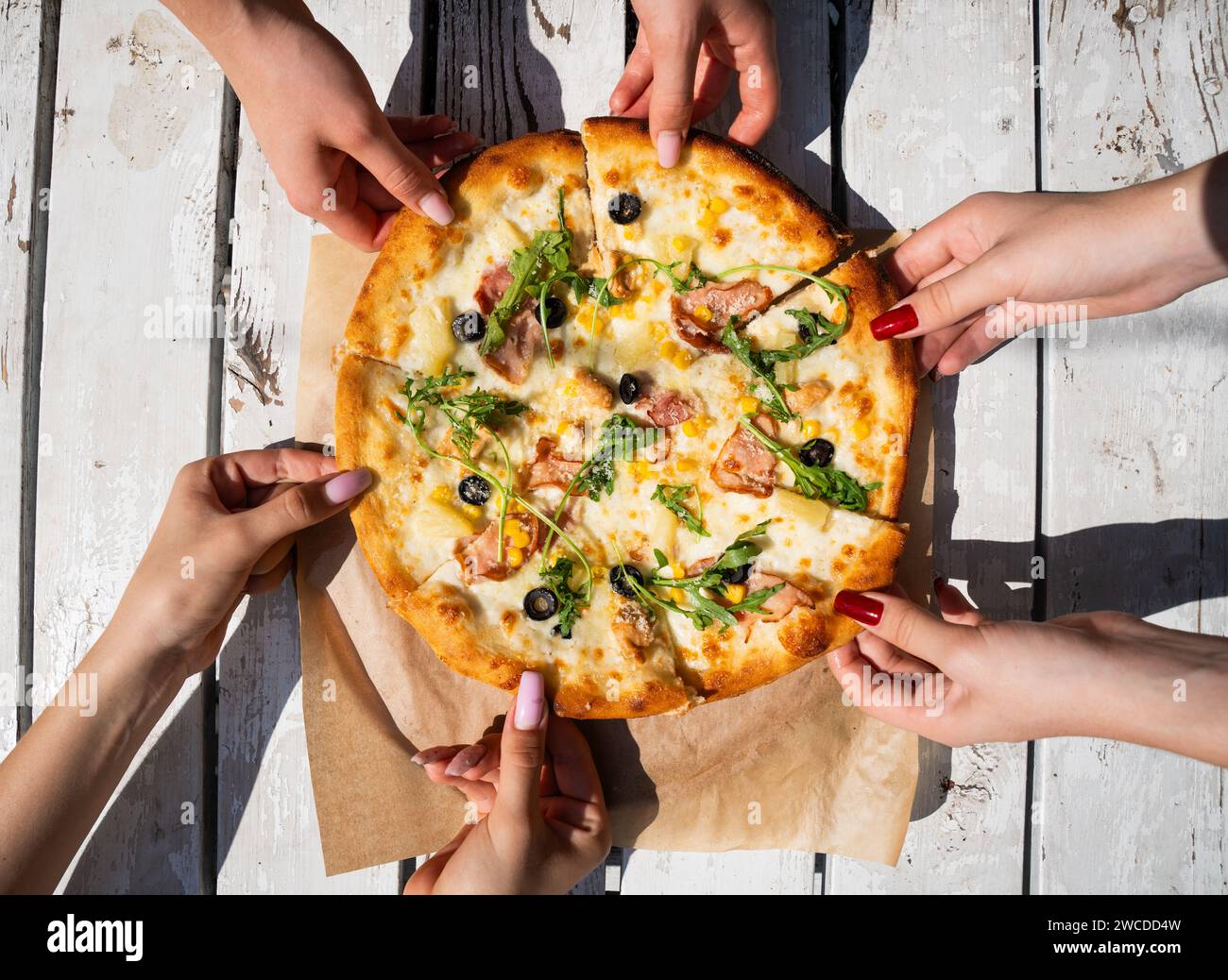 Overhead view of a freshly baked artisan pizza with arugula, olives ...