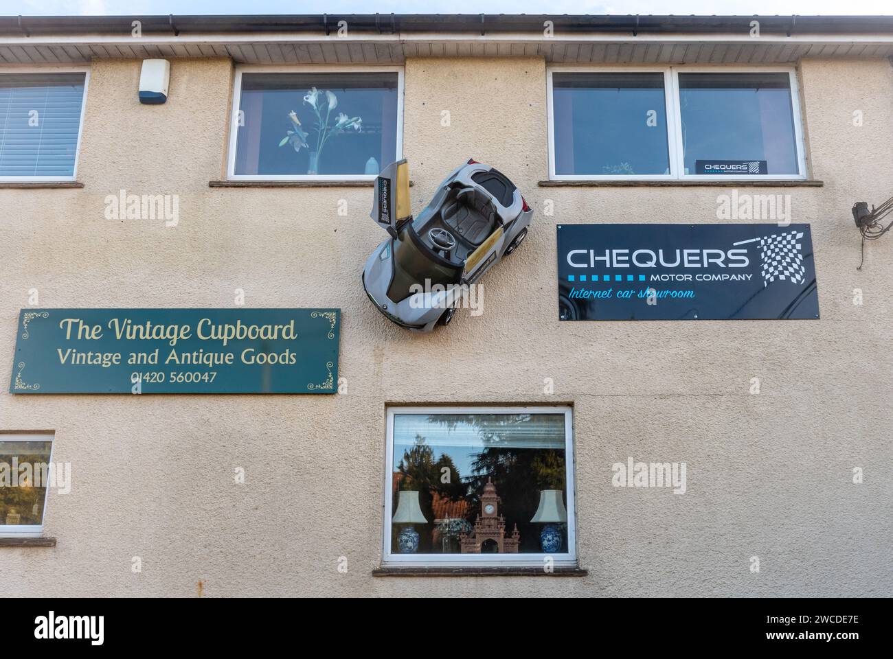 Quirky shop front with a car on the wall at Chequers Motor Company ...