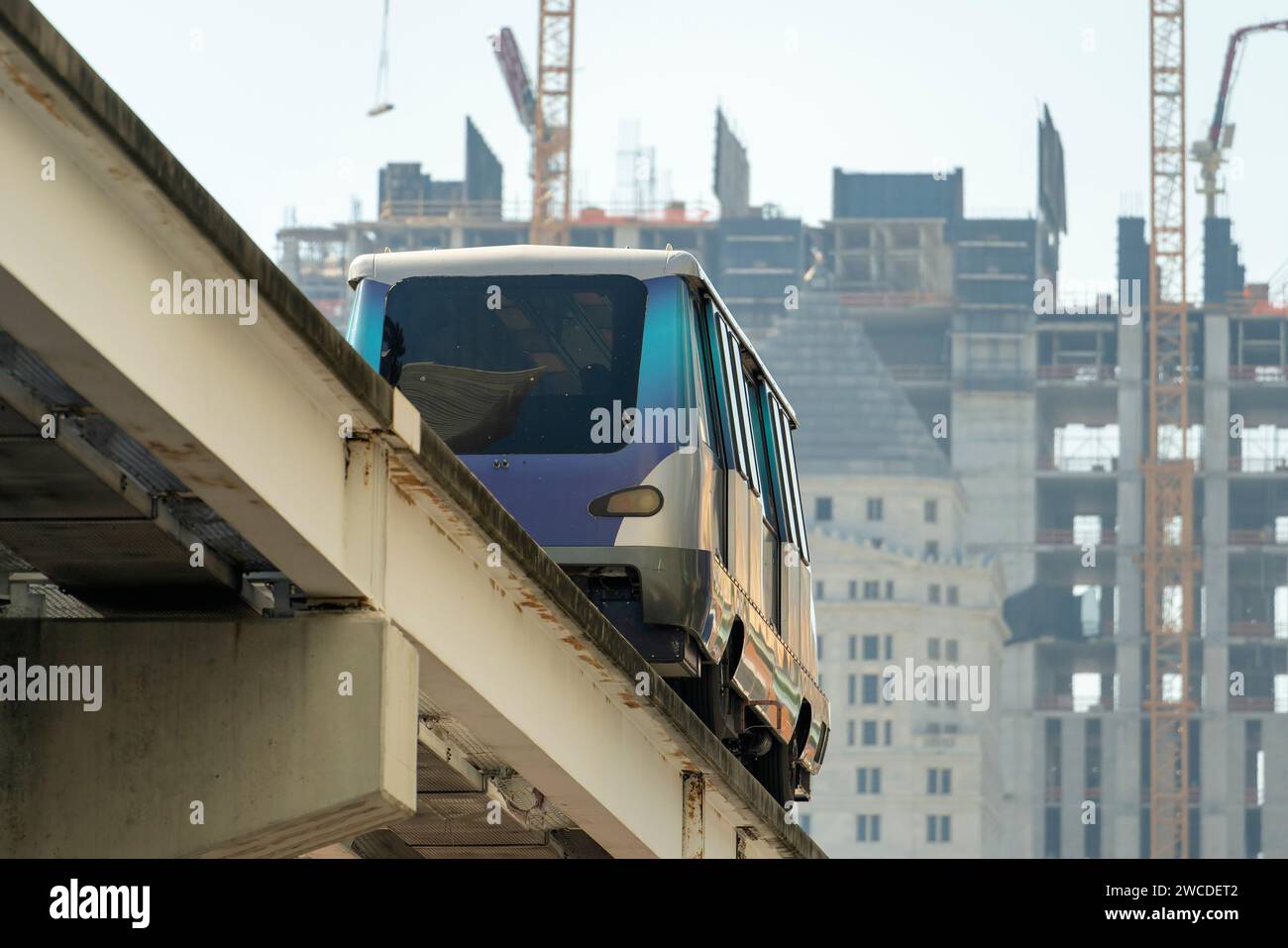 City train car on high railroad over street traffic between skyscraper ...