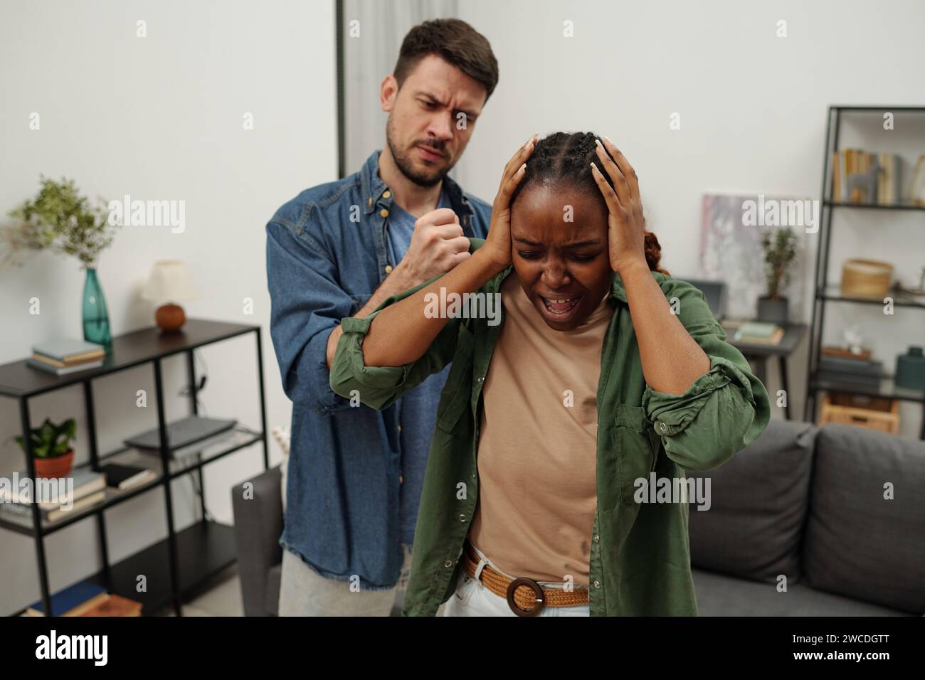 Young African American woman touching head by hands while standing in ...