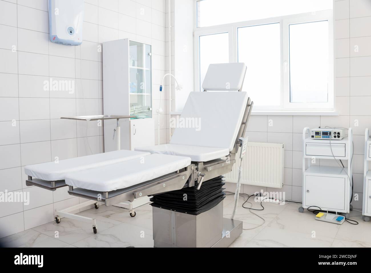 Hospital interior design with operating table and lamp with cabinets and modern devices in light ...