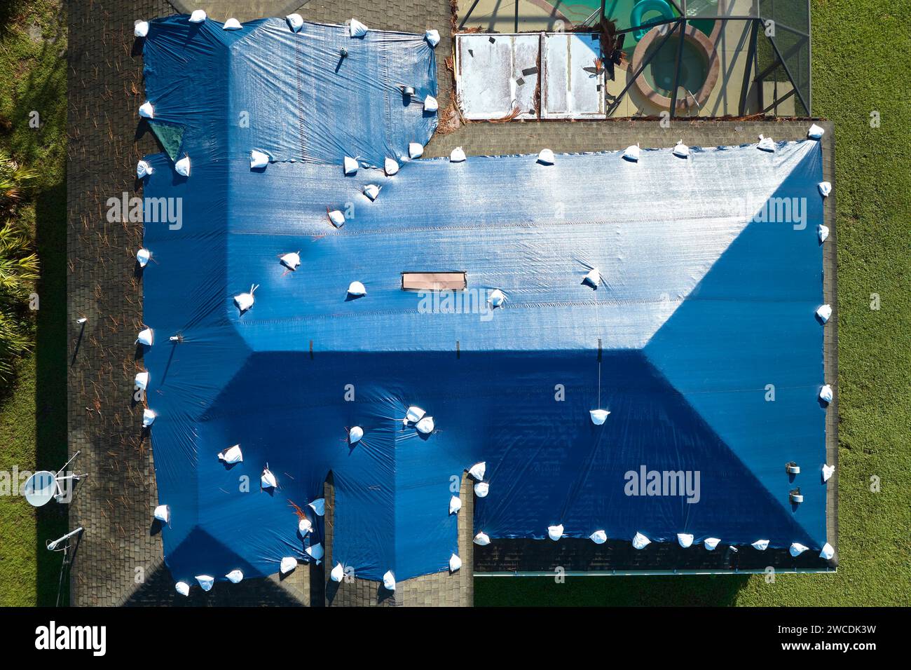 Top view of leaking house roof covered with protective tarp sheets ...