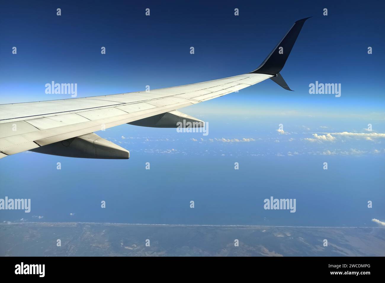 View through airplane window of commercial jet plane wing flying high ...