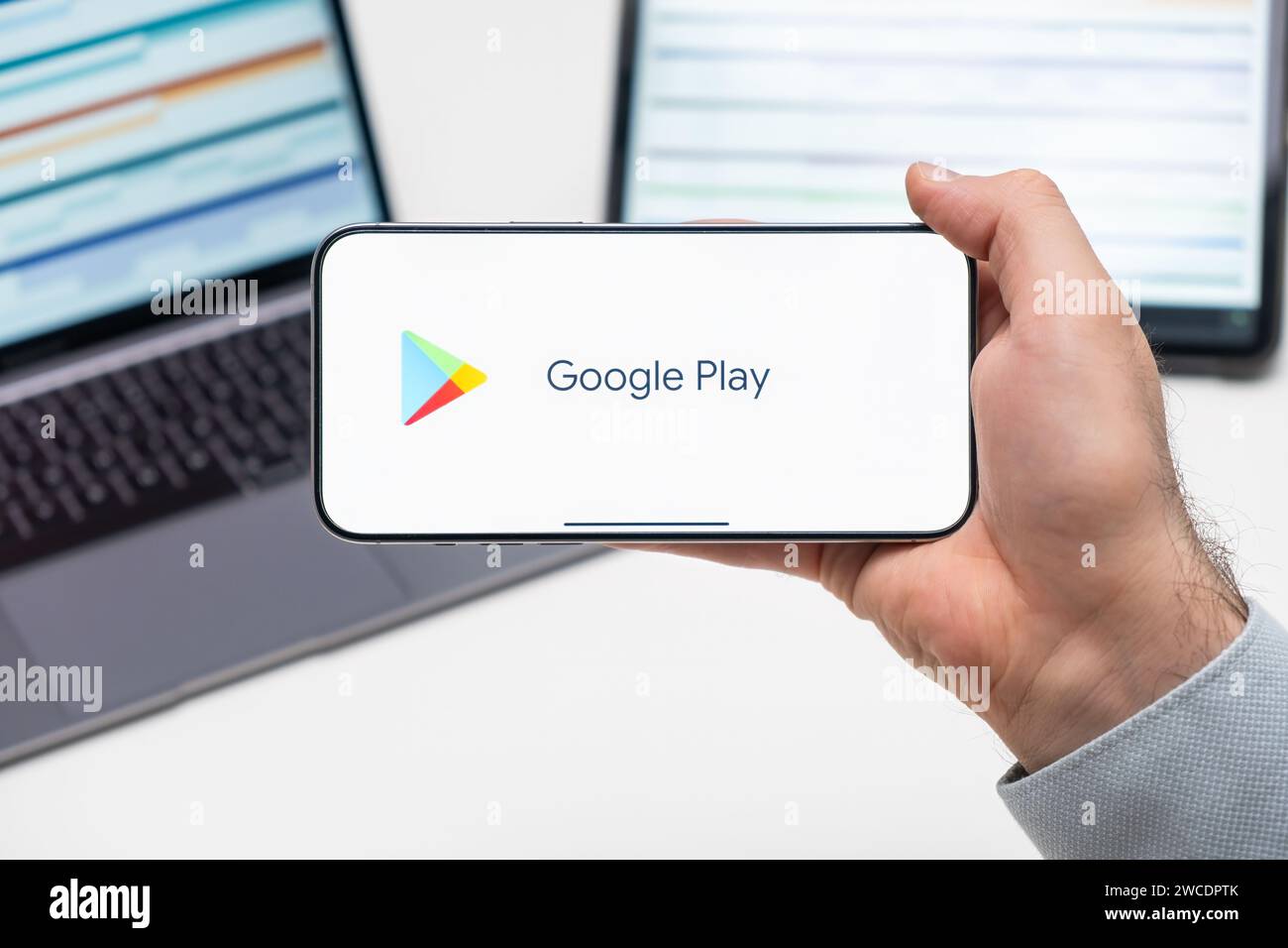 Google play logo of app on the screen of mobile phone held by man in ...