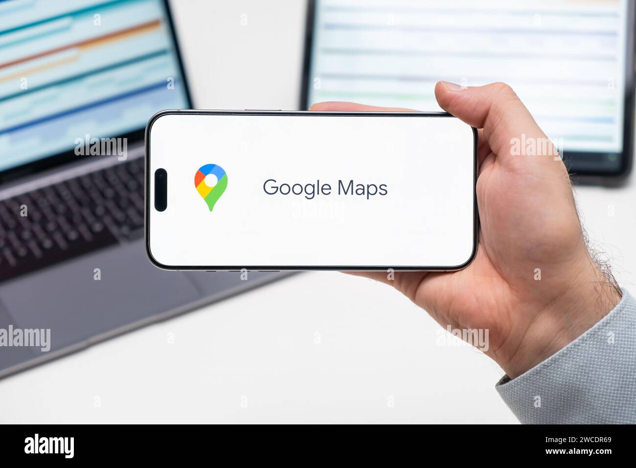 Google Maps logo of app on the screen of mobile phone held by man in ...