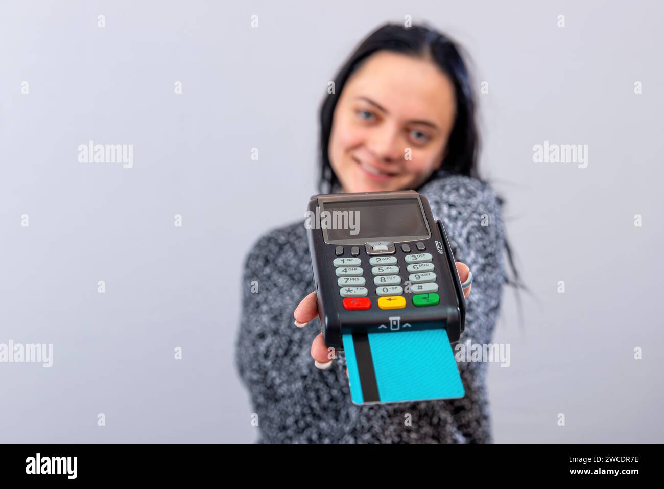 caucasian female holding payment terminal and giving it to the customer ...