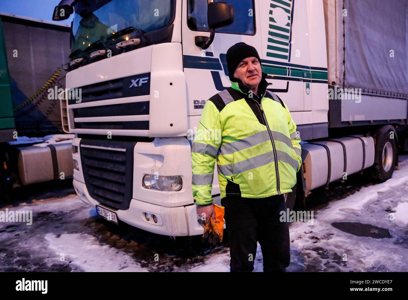 Medyka, Poland, January 15, 2024. Truck driver stands in front of his ...