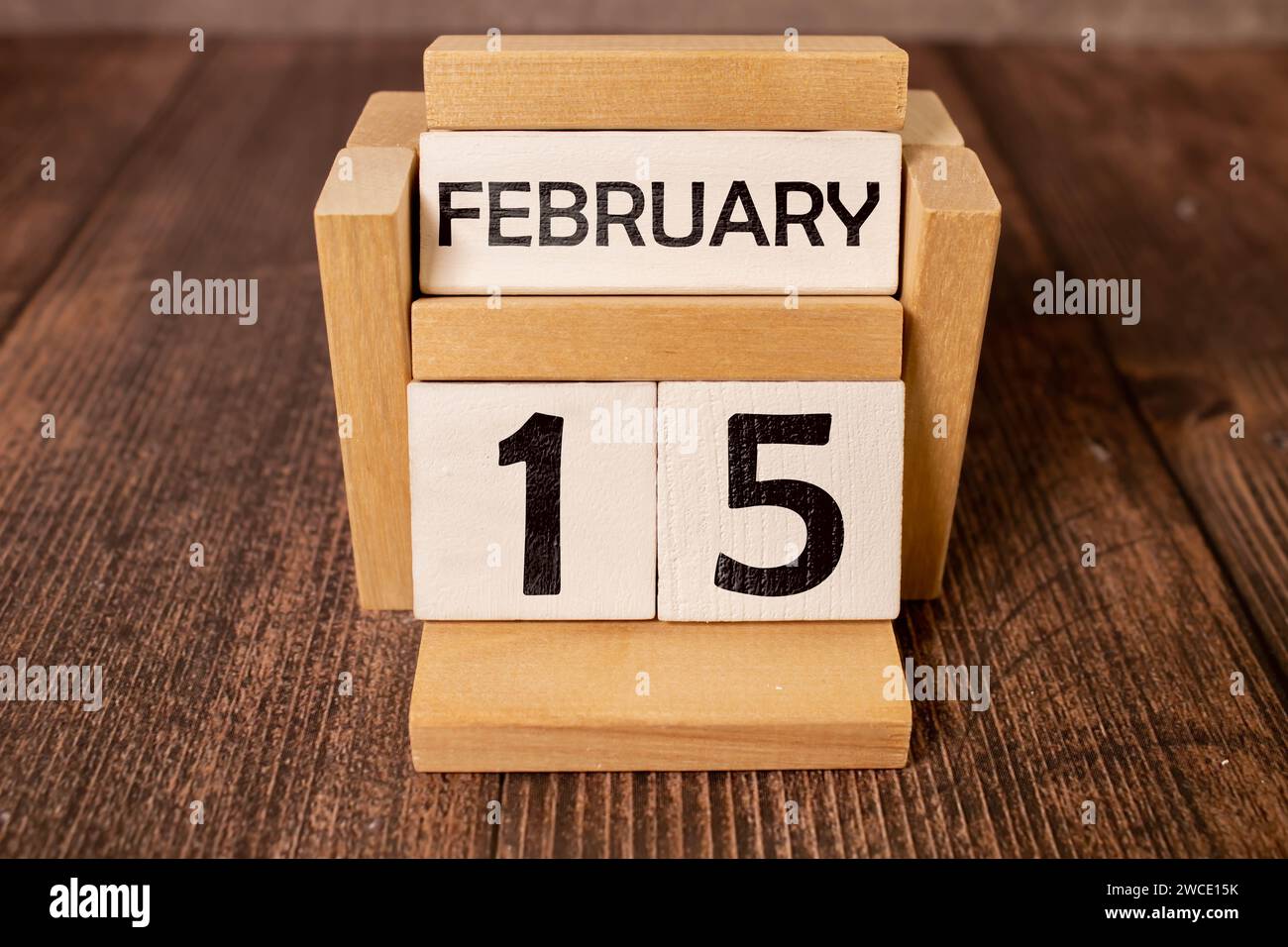 Cube shape calendar for february 15 on wooden surface with empty space ...