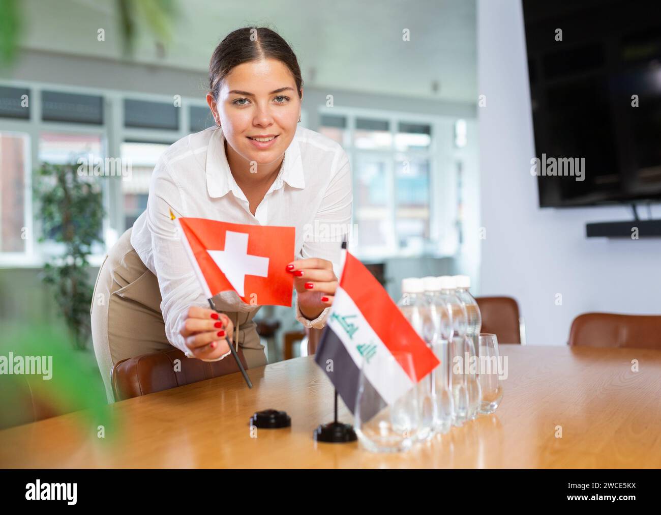 Female secretary places flags of the Iraq and Switzerland flag on the ...