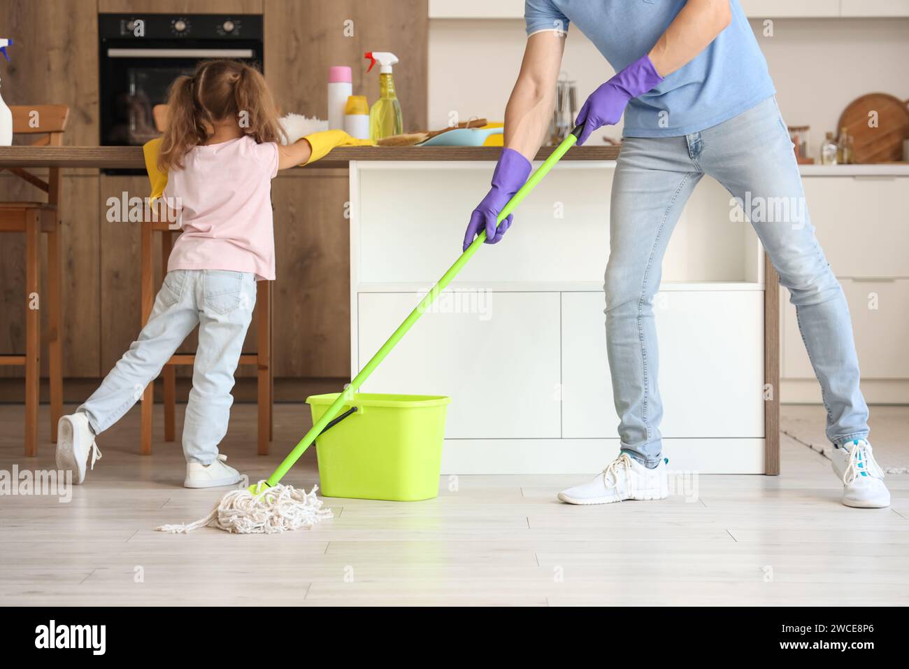 Cute little girl with her dad cleaning in kitchen Stock Photo - Alamy