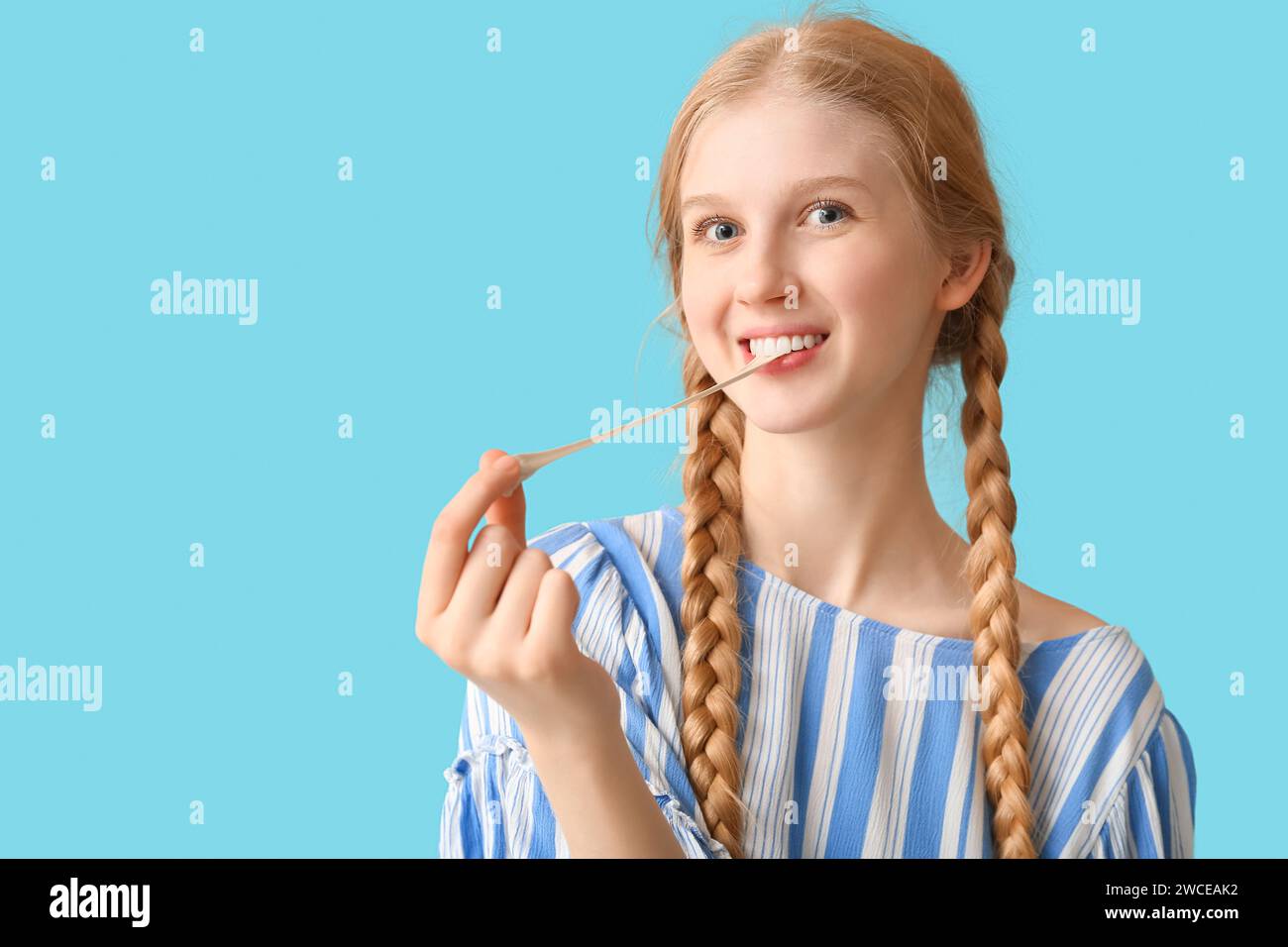 Teenage girl chewing gum on blue background Stock Photo - Alamy