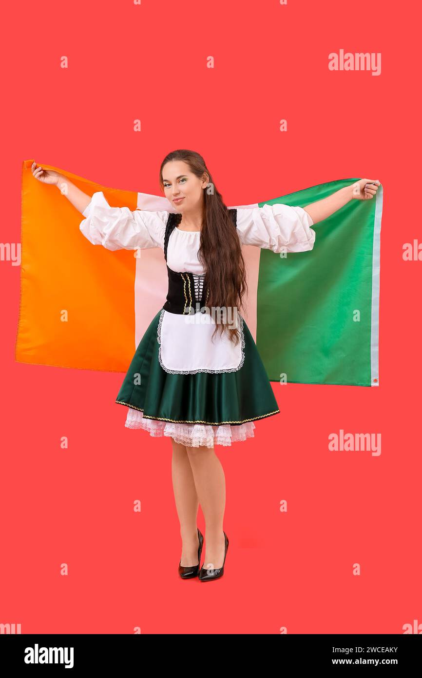 Young woman with flag of Ireland on red background. St. Patrick's Day ...