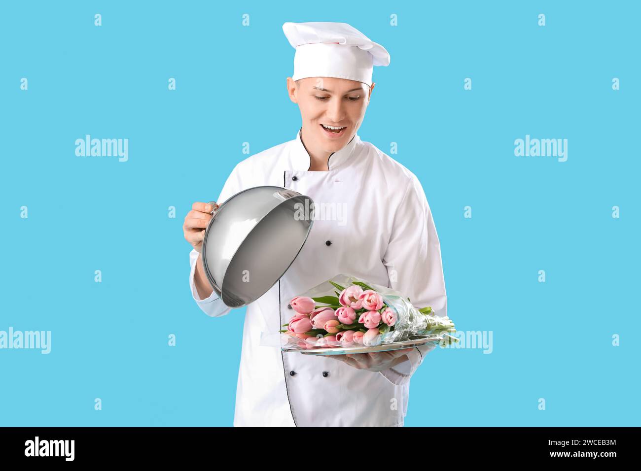 Male chef with cloche and tulips on blue background. International ...