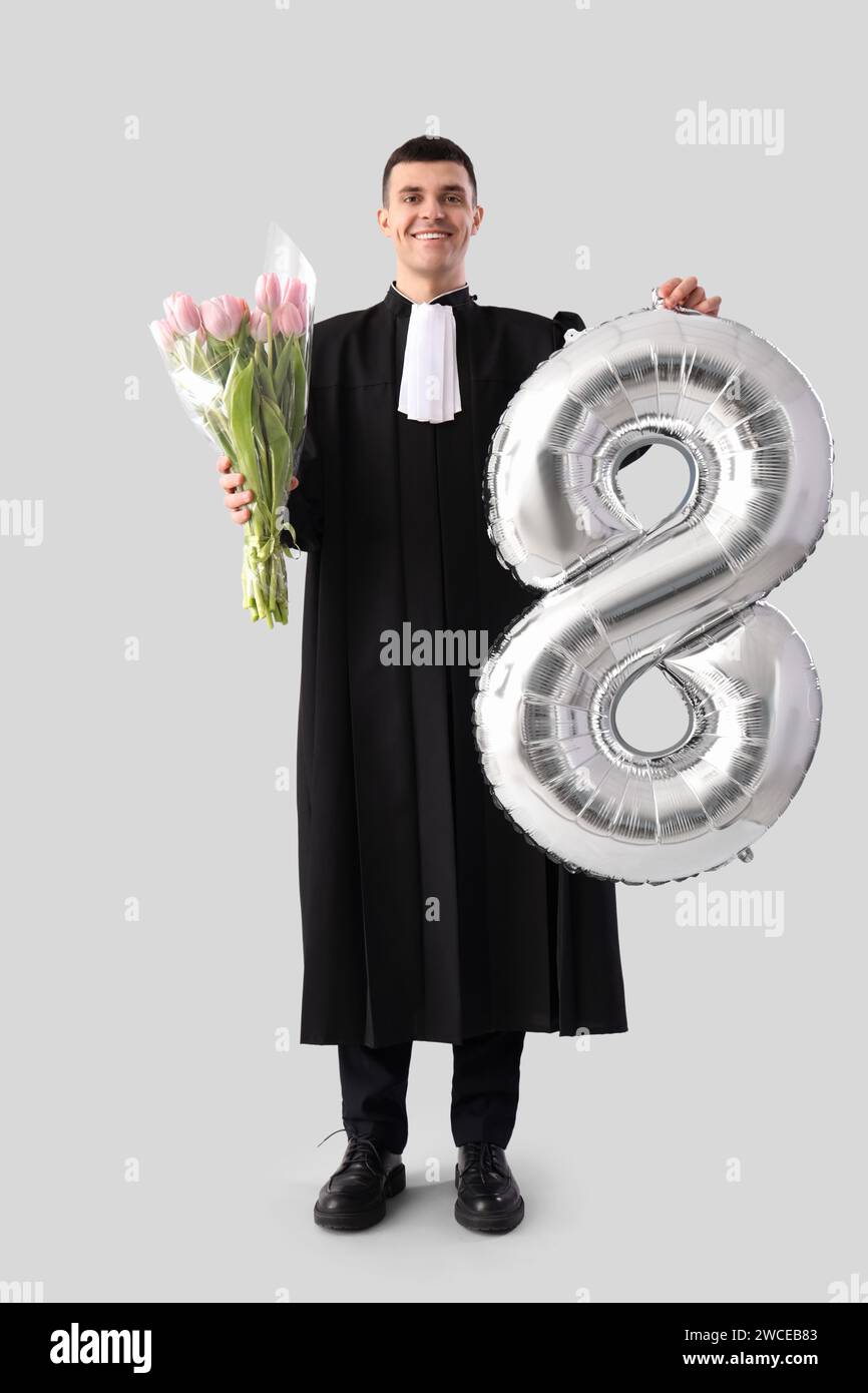 Male judge with tulips and balloon in shape of figure 8 on light ...