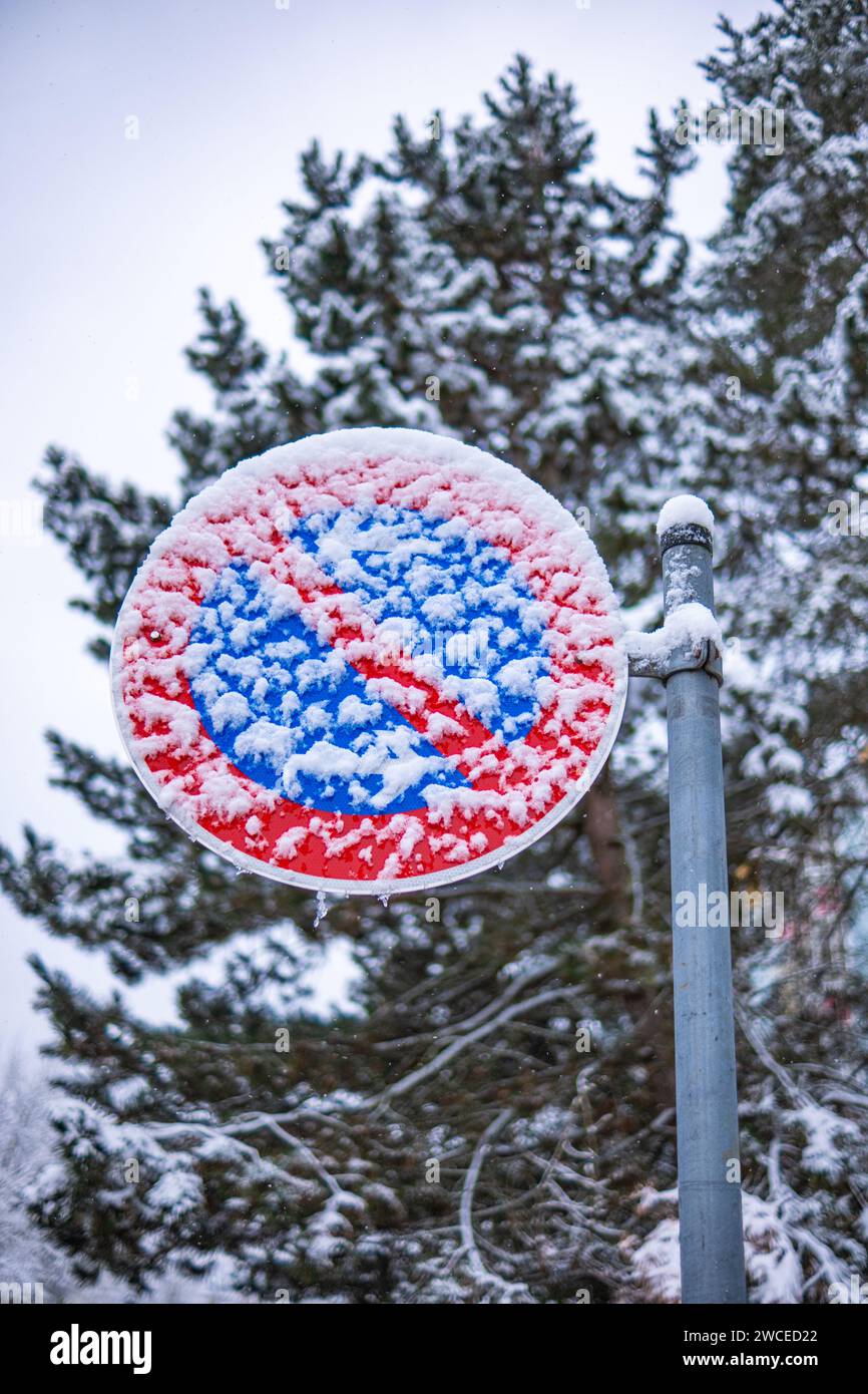 A road sign prohibiting parking is covered with sticky snow. "No ...