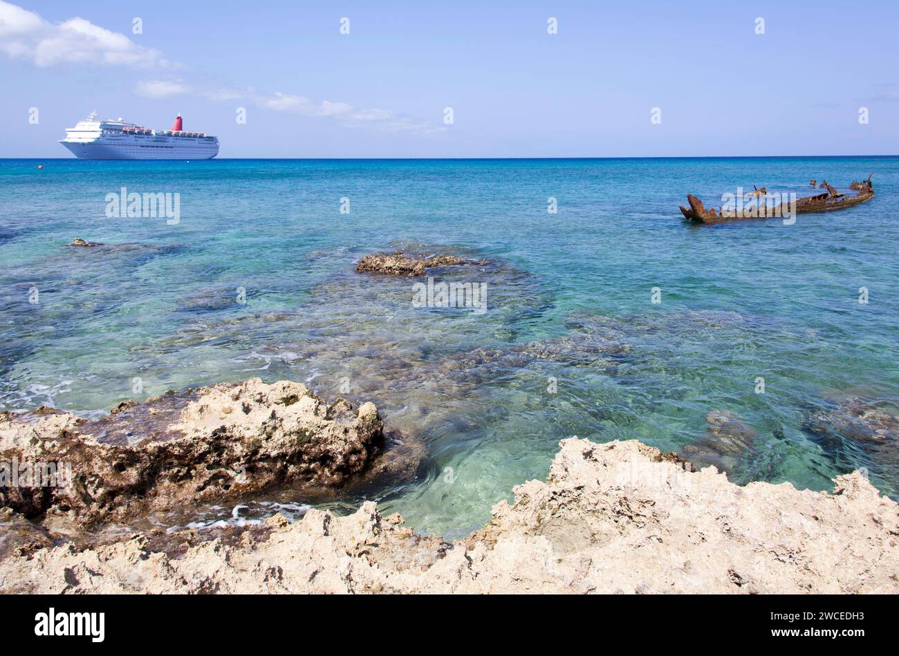 The scenic view of a rocky Grand Cayman island shore with a cruise ship ...