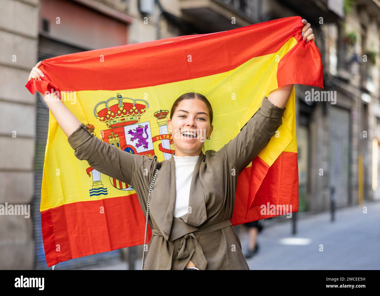 Young smiling woman holding Spain flag Stock Photo - Alamy
