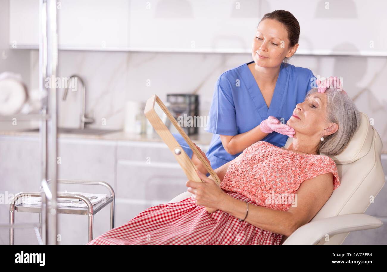Adult female doctor examining face of female patient Stock Photo - Alamy