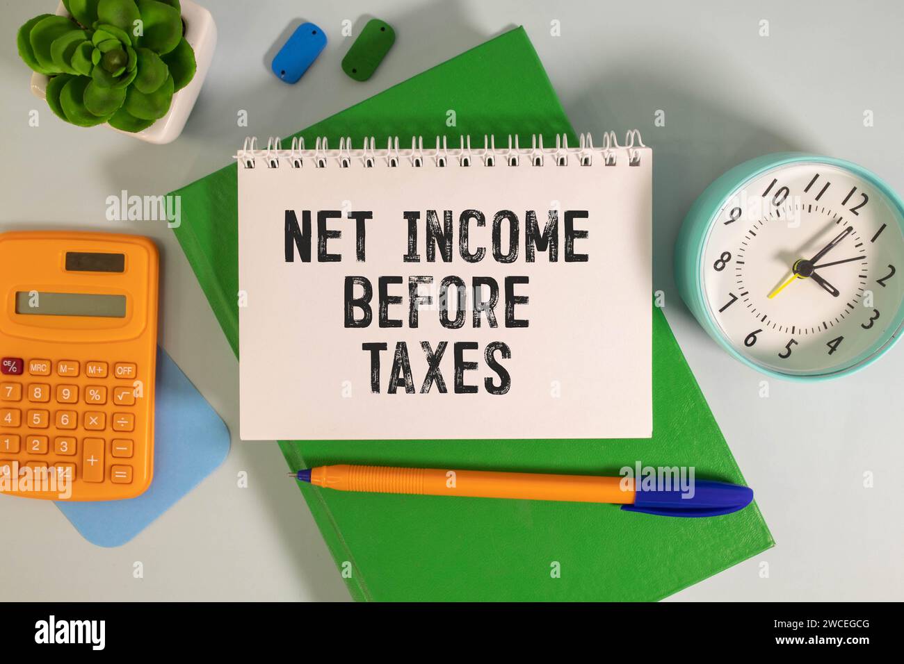 Net Income Before Taxes, text on white paper on torn paper background ...