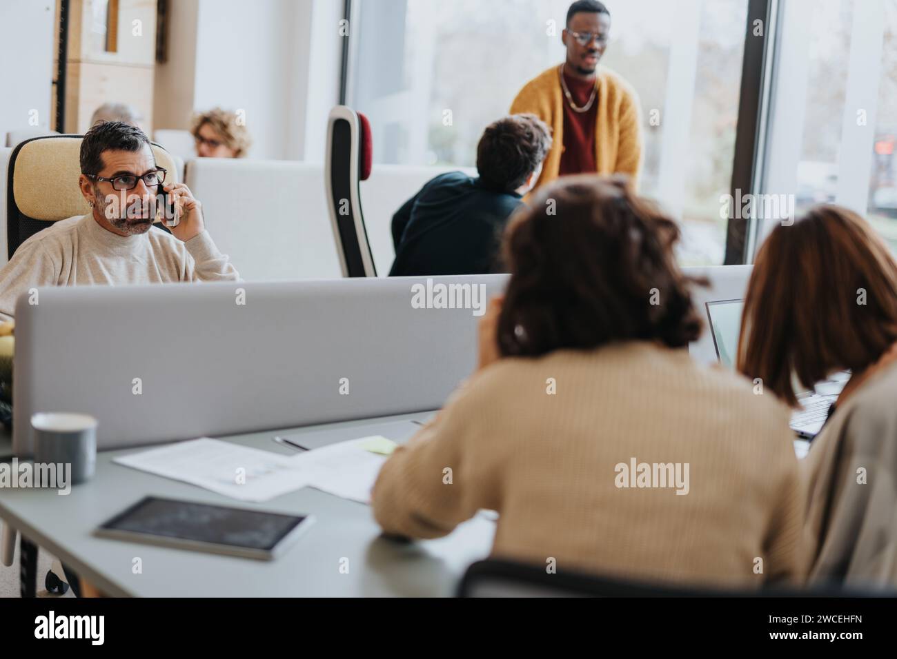 Multiracial and cross generational group of coworkers collaborating in ...